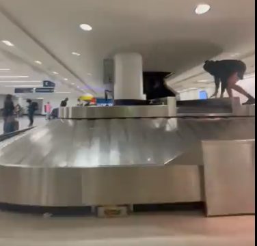 Young Child Jumps On Baggage Carousel While Tossing Luggage - View from ...